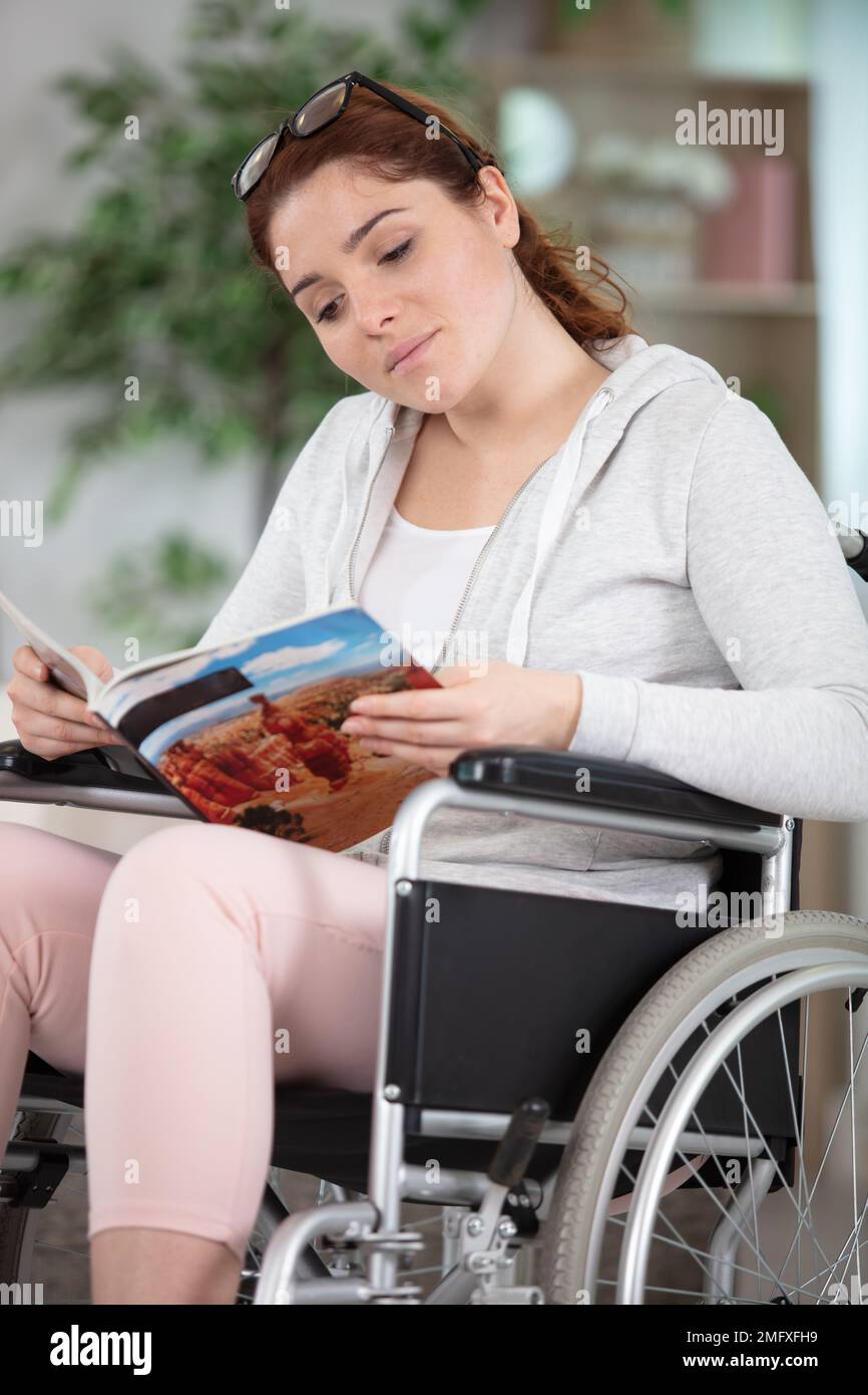 disabled woman sitting in a wheelchair and holding a magazine Stock ...