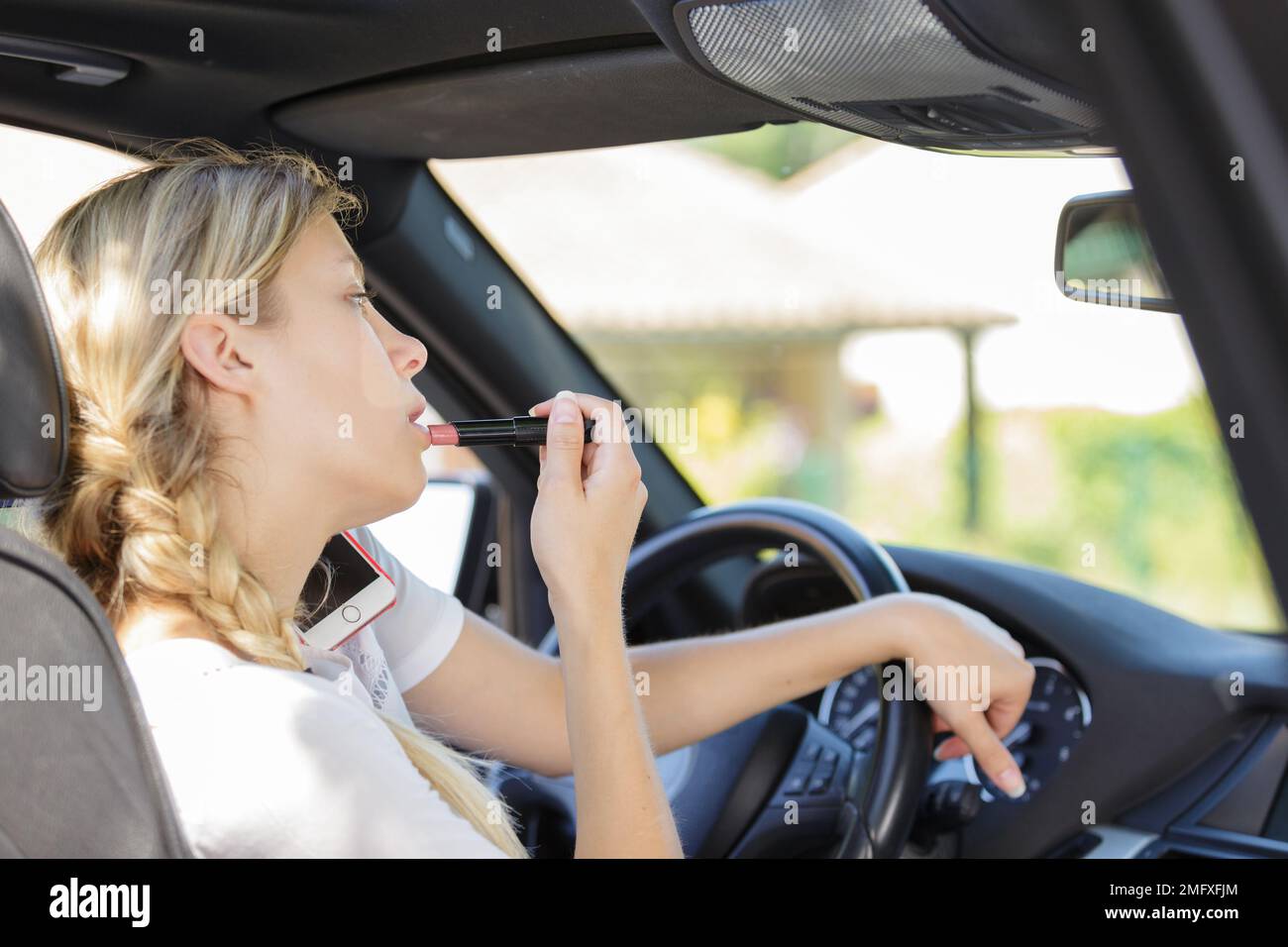 beautiful woman makes up lips in the car Stock Photo - Alamy