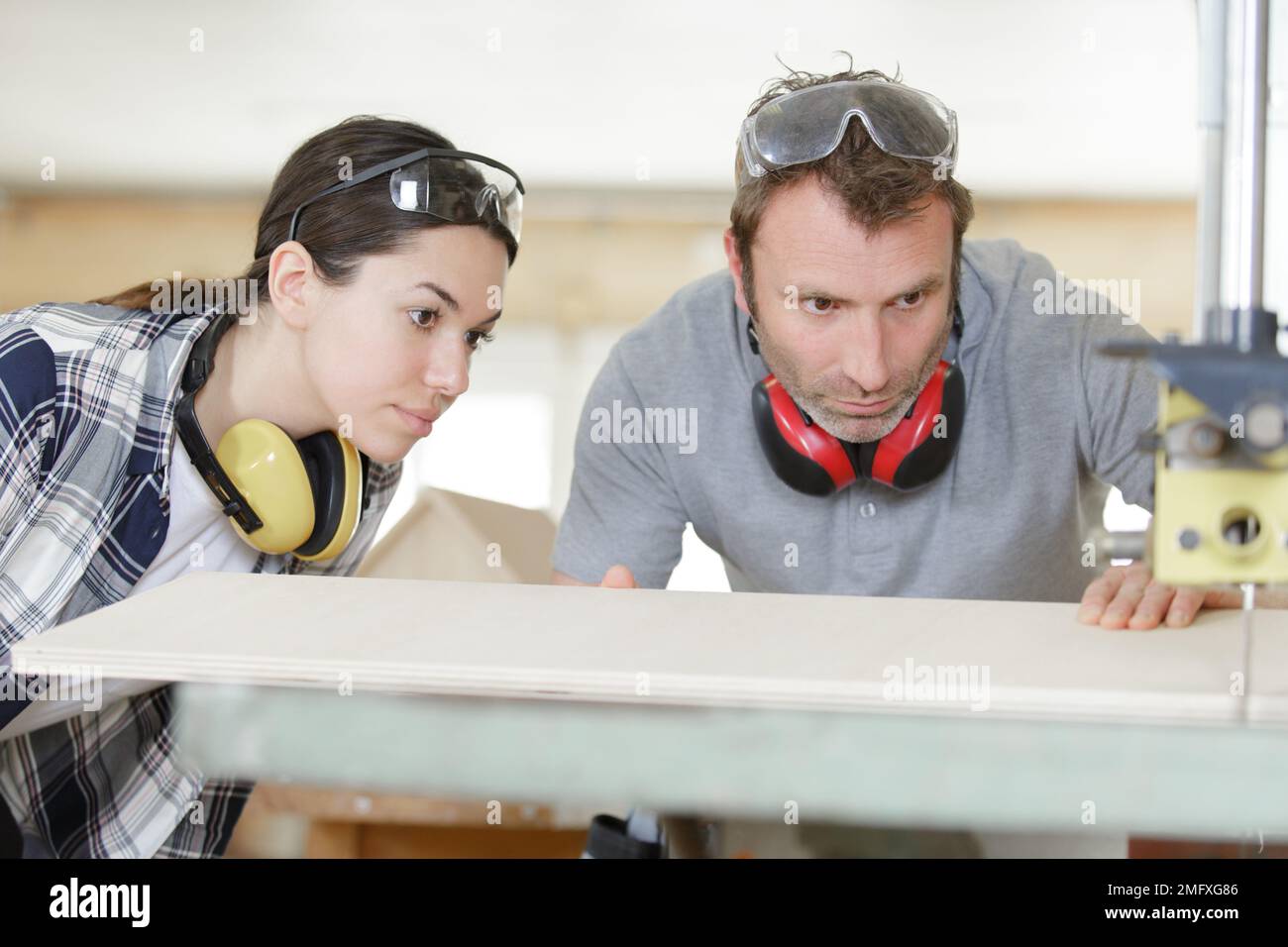 carpenter training female apprentice to use plane Stock Photo - Alamy
