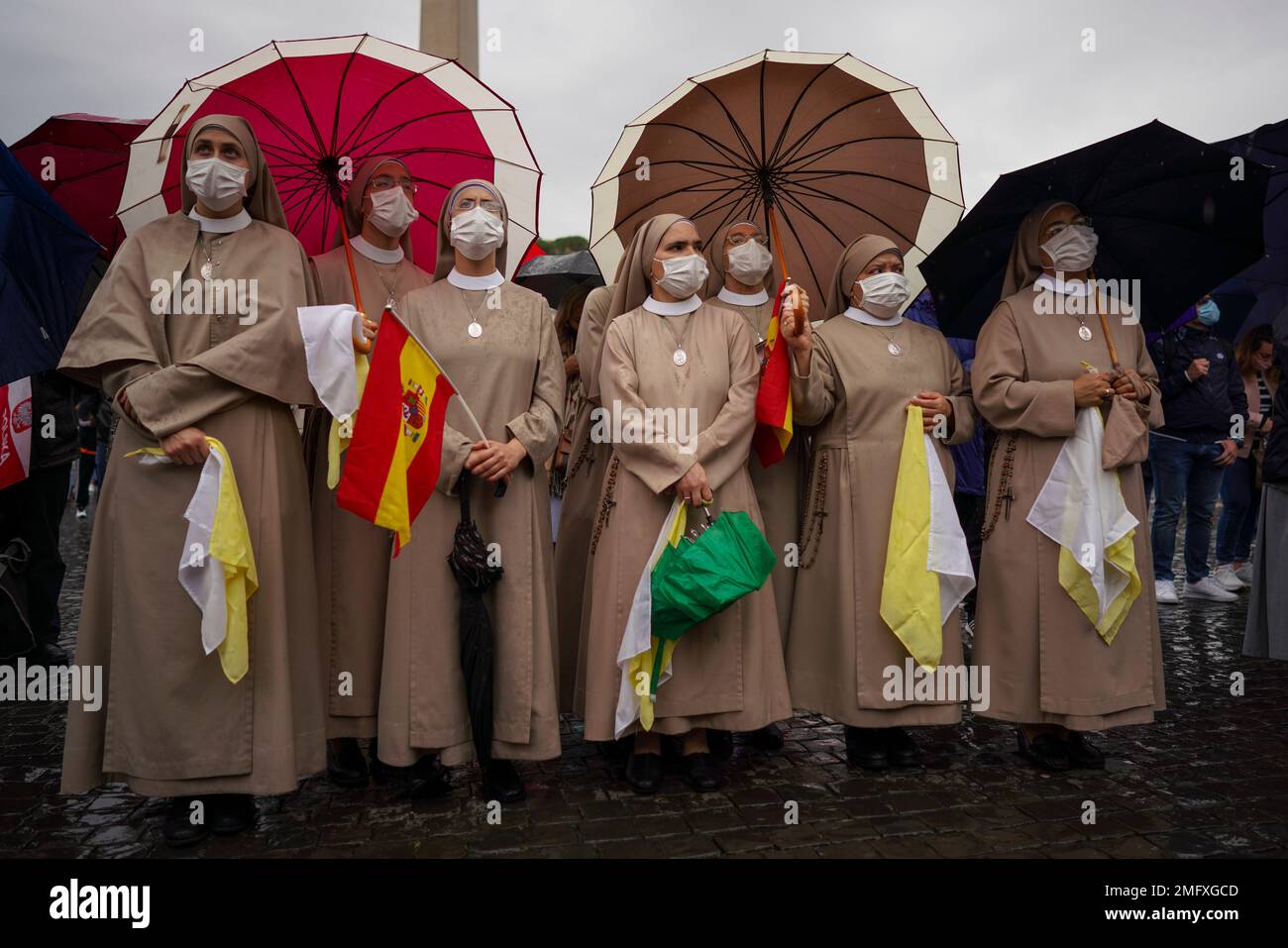 Nuns, wearing protective face masks, follow Pope Francis as he recites ...