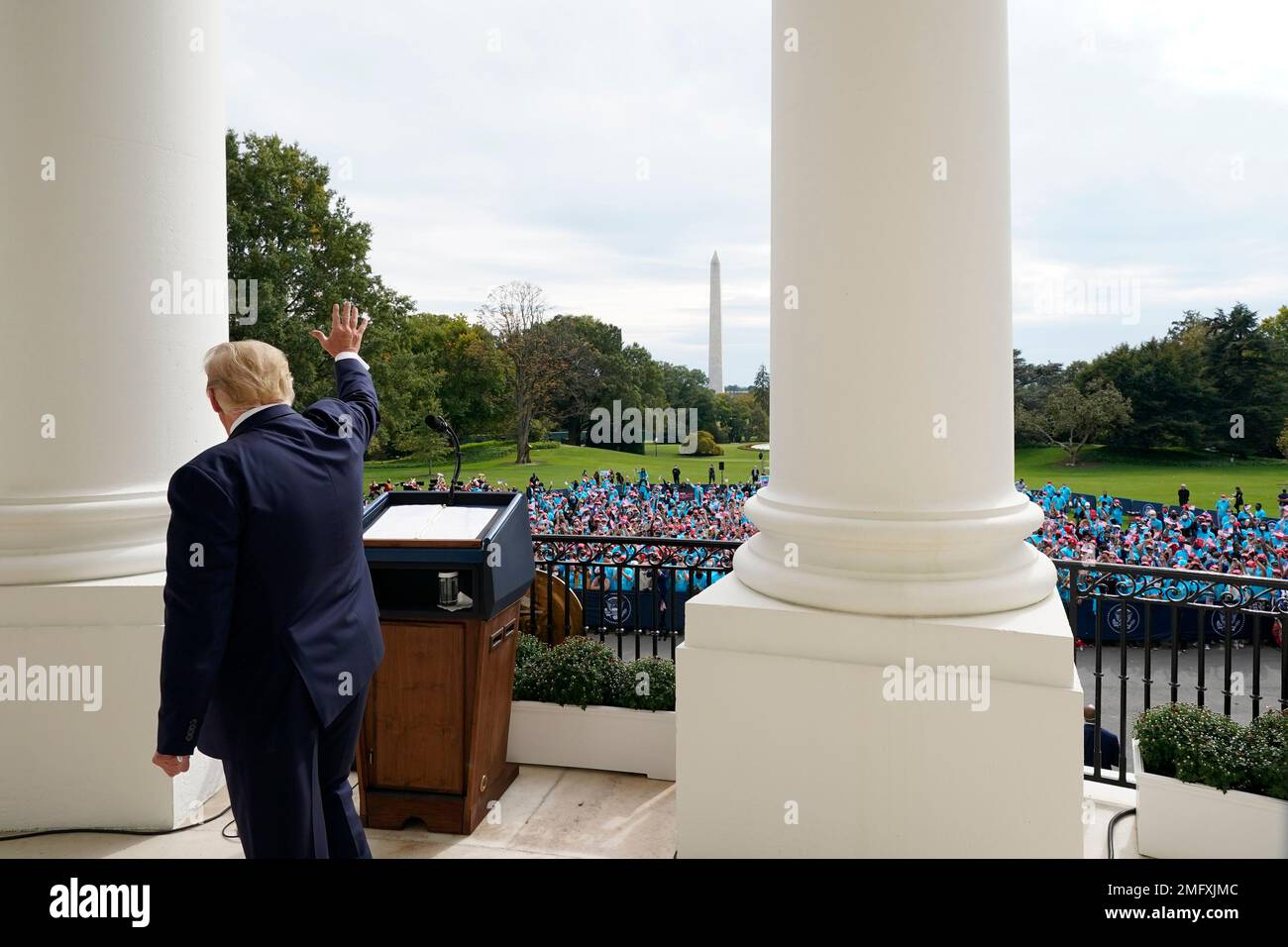 President Donald Trump waves from the Blue Room Balcony of the White ...