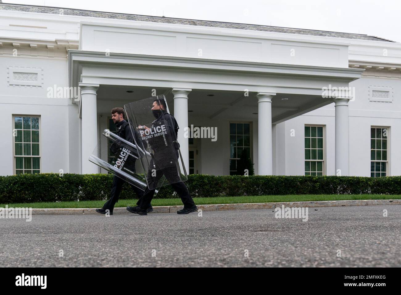 Officers with U.S. Secret Service carry shields and batons past the ...