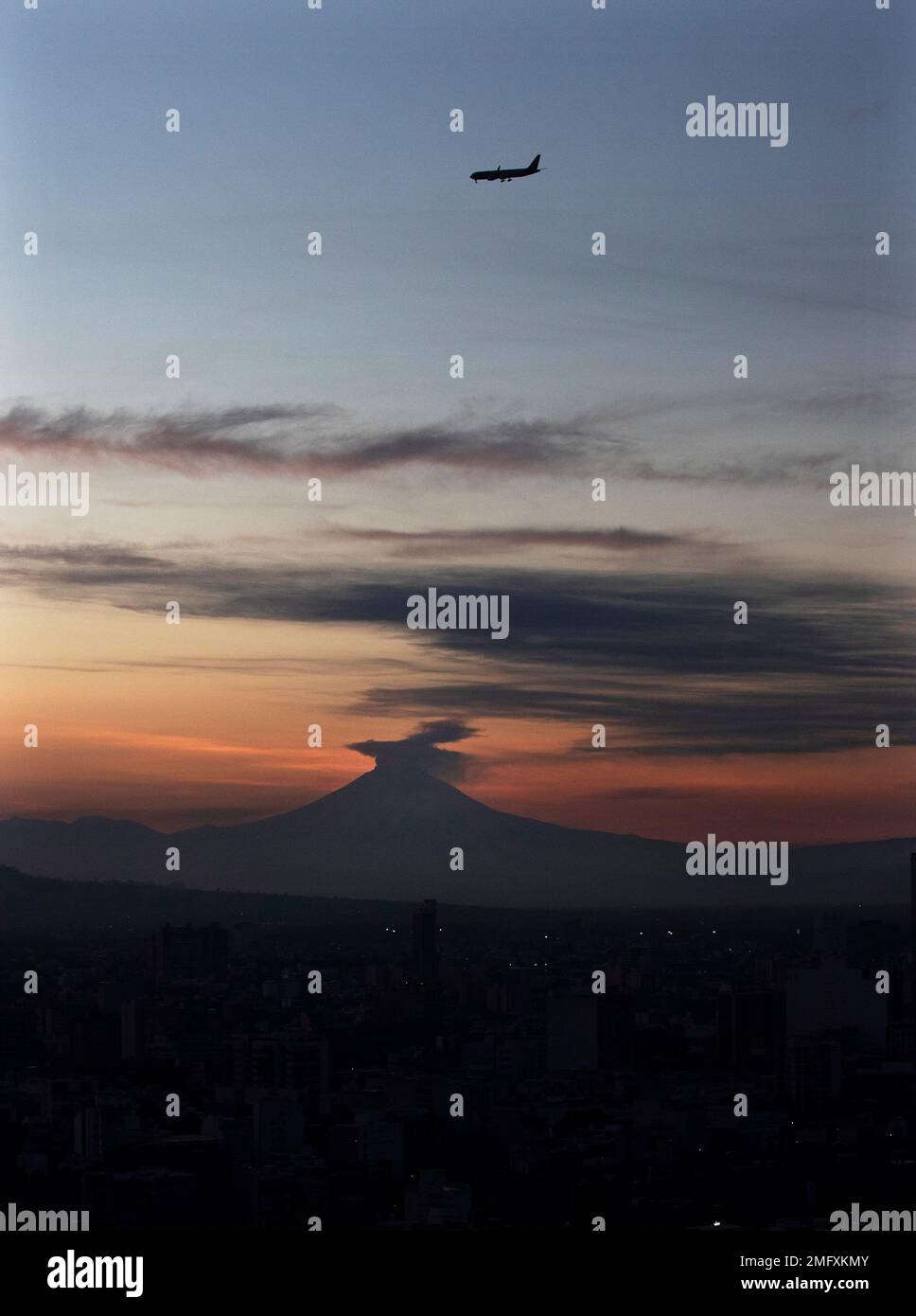 The Popocatepetl volcano emits smoke and ash at sunrise, seen from ...