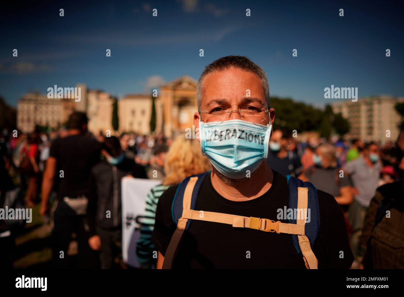 A woman wears a mask reading in Italian Liberazione (Liberation) as ...