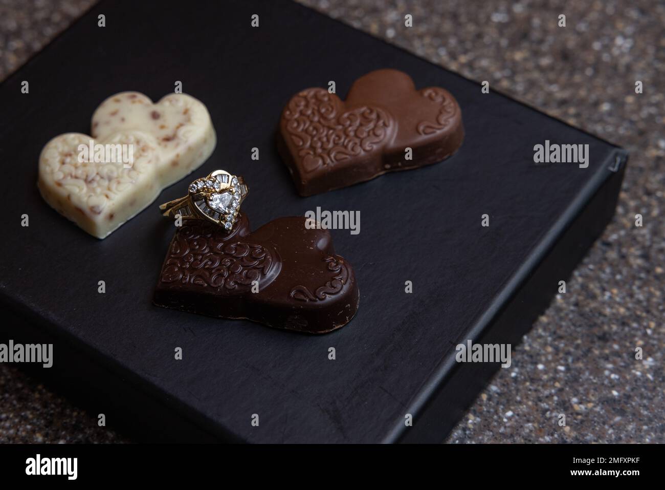 heart shaped ring with chocolates on a black box lid Stock Photo - Alamy