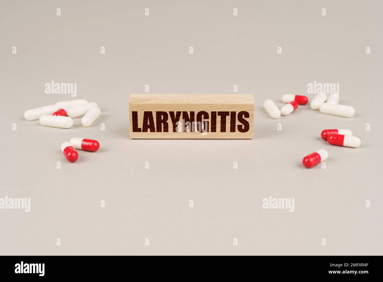 Medical concept. On a gray surface are tablets, capsules and a wooden ...