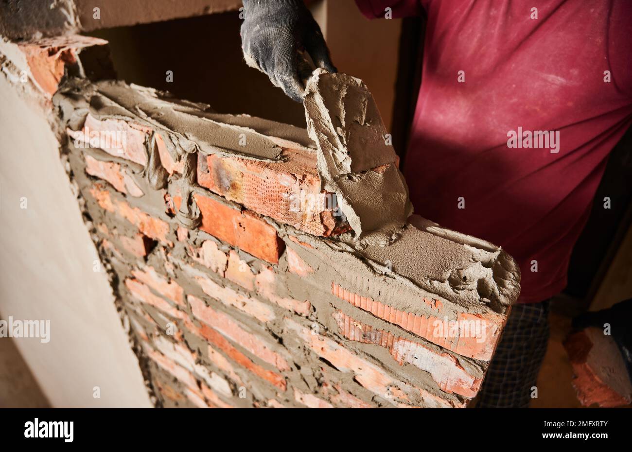 Close up of man hand in work glove laying brickwork in building under ...