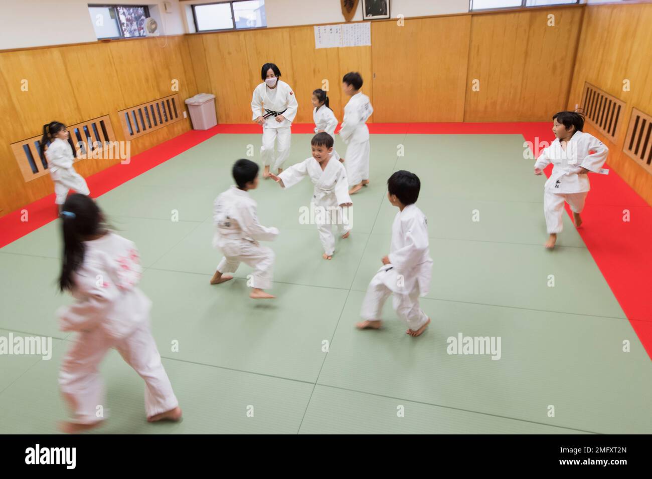 Students with their judo teacher Miyoko Hamana, back left, run around ...