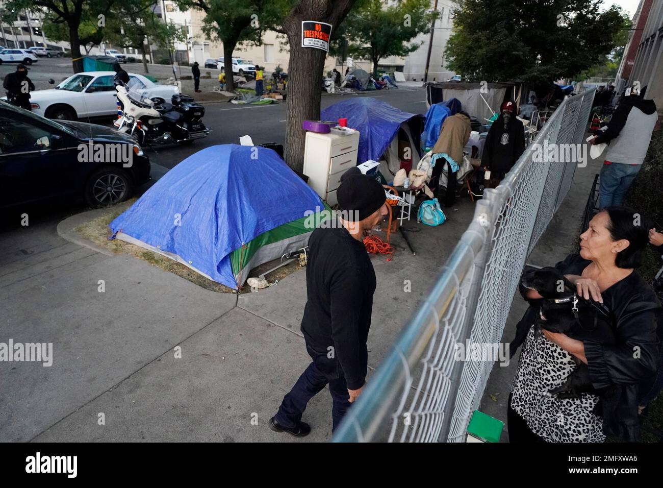 A man chats with a woman during a sweep of a homeless encampment around ...