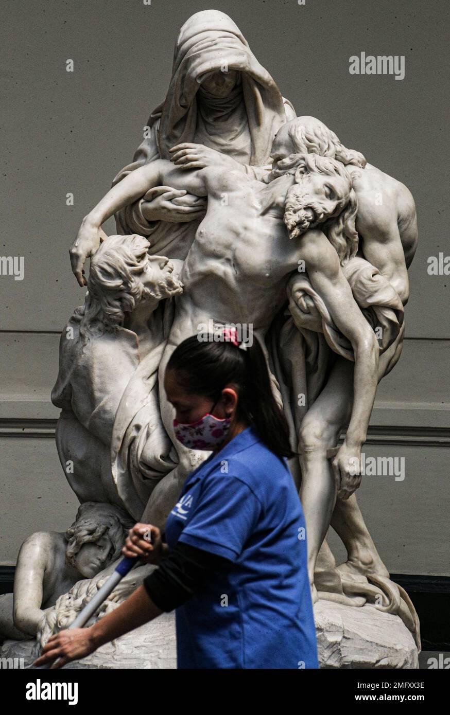 A worker sweeps the floor in front of the "El Descendimiento' sculpture ...