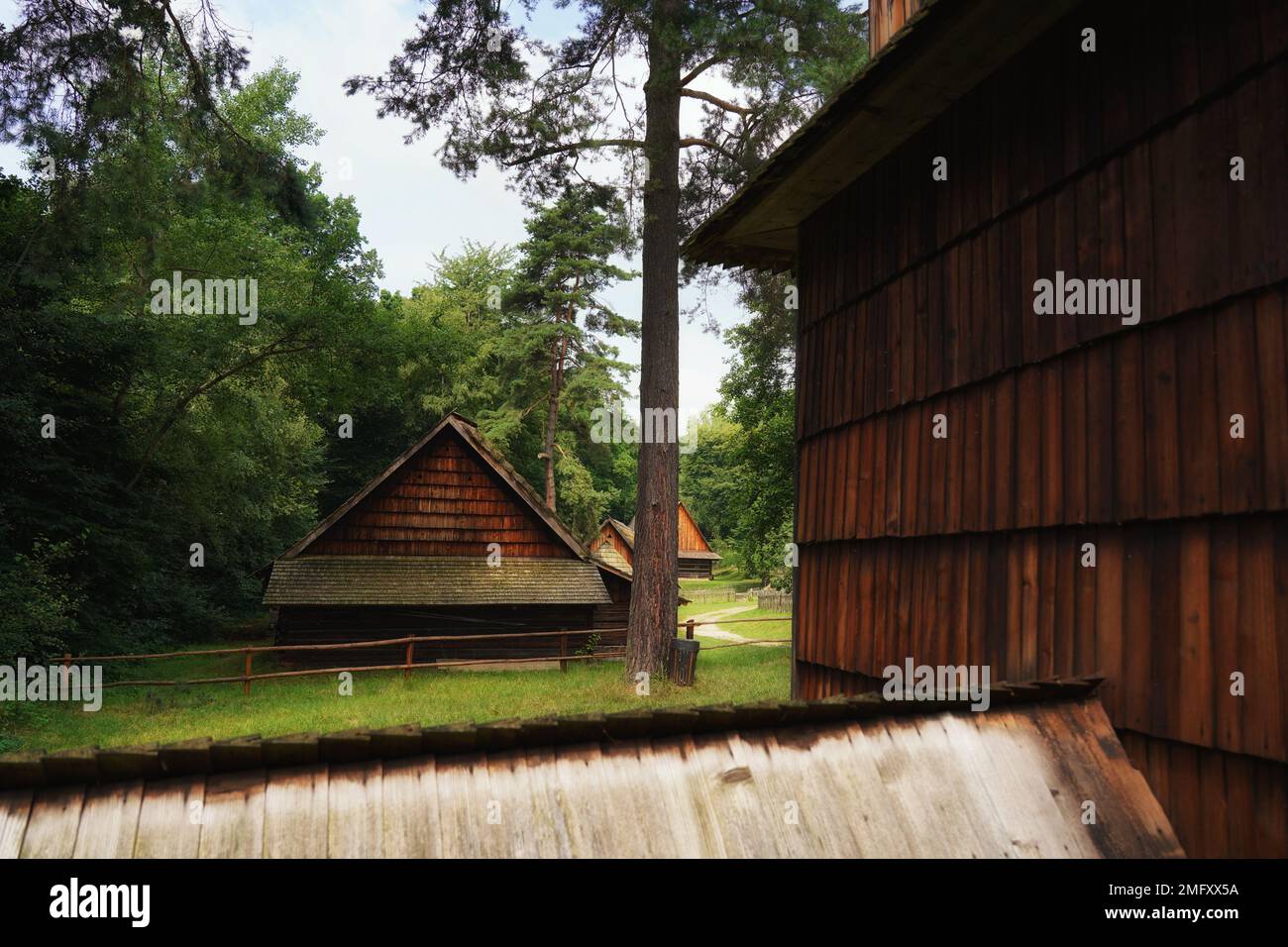Sanok, July in the open-air museum, wooden buildings among the trees ...