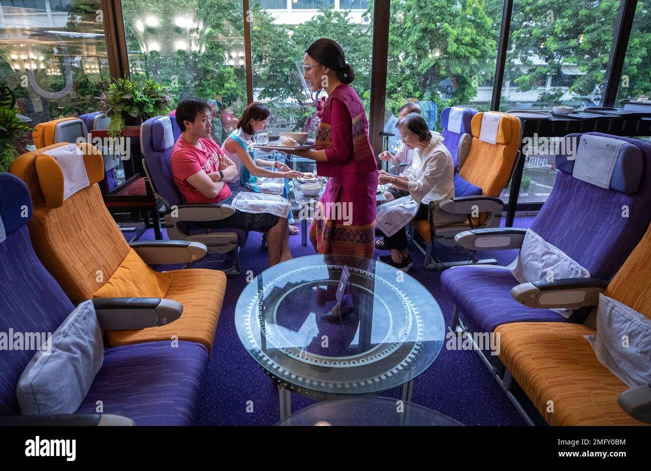 A flight attendant serves meals in a flight-themed restaurant at the ...