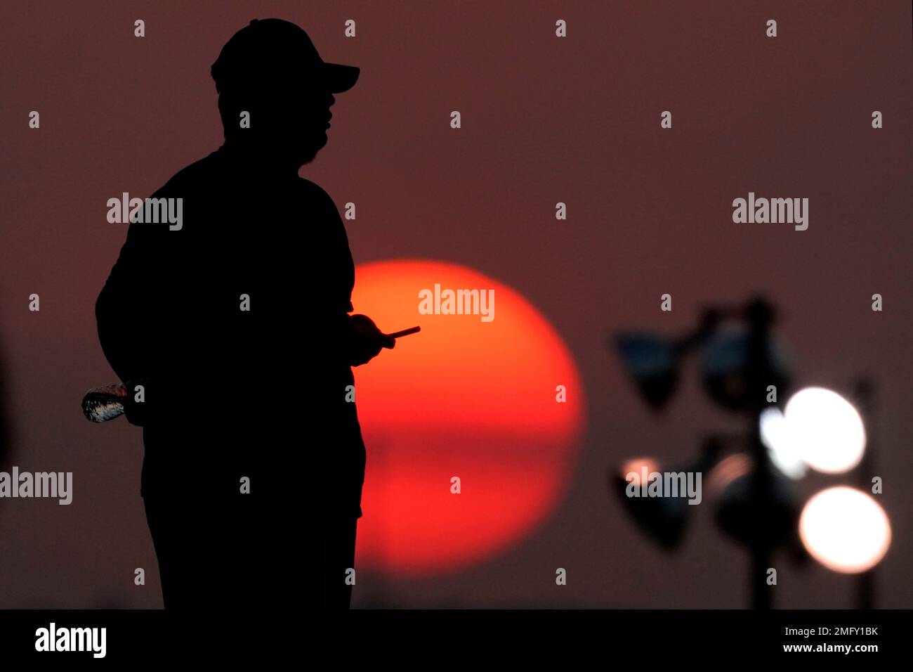 A man watches the setting sun as smoke from western wildfires continues ...