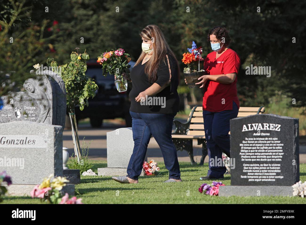 Lori Gonzalez, left, and Rachel Spray carry flowers to the temporary ...
