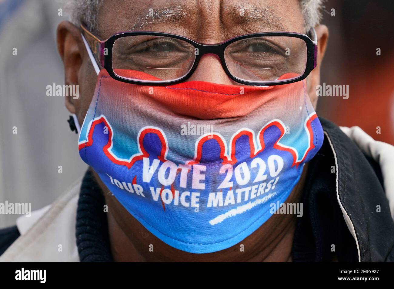 A voter waits in line to participate in early voting at the Cuyahoga ...