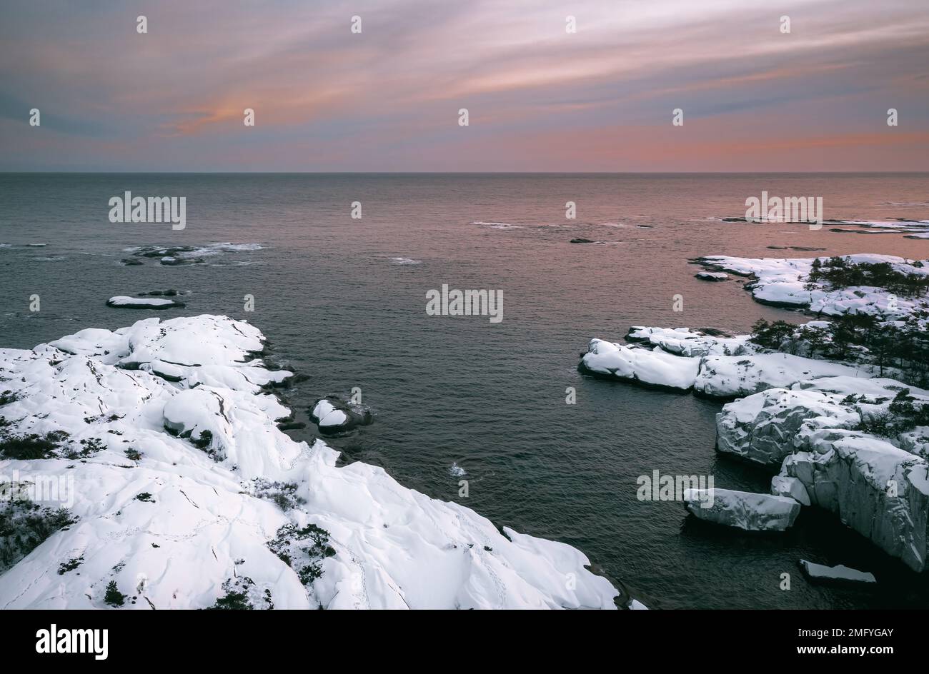 Aerial view of snowy sea coast, colorful sky at sunset in Norway ...