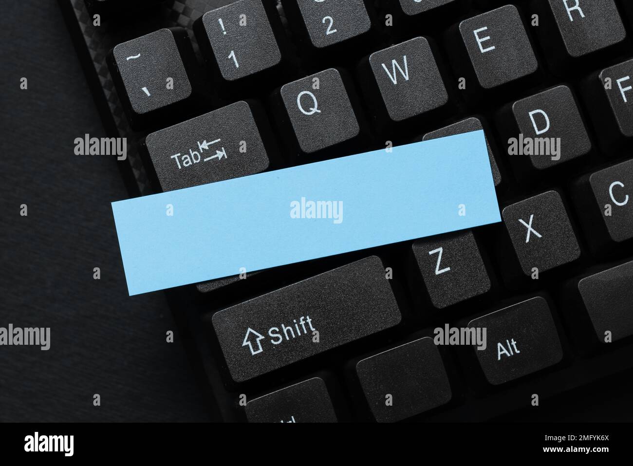 Colored sticker lying on black keyboard. Important information written ...