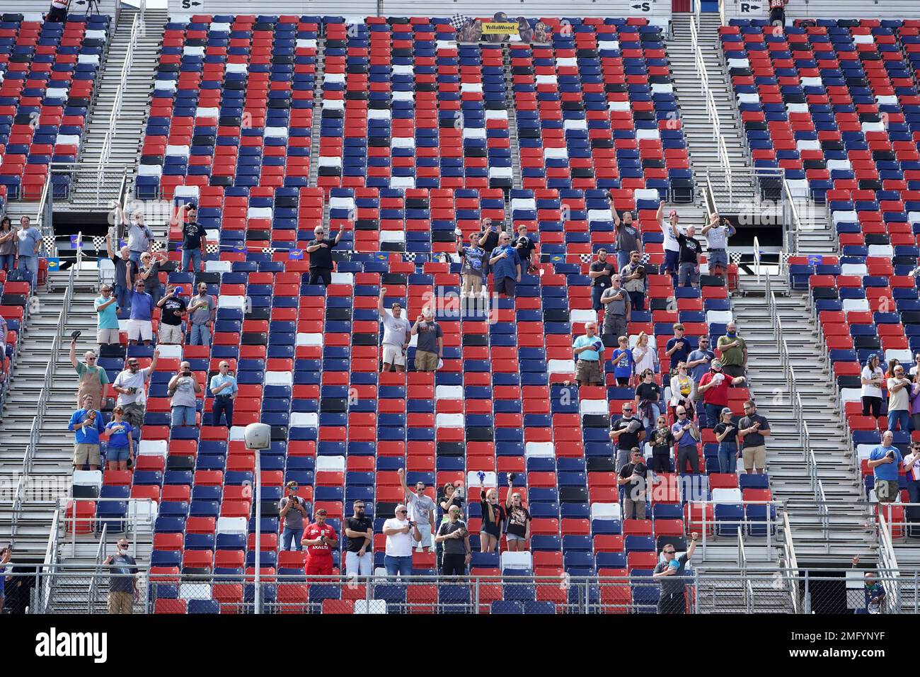 Race fans stand for the national anthem before the YellaWood 500 NASCAR ...