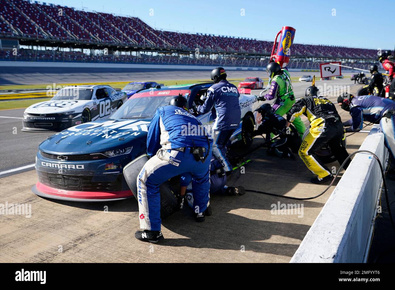 Crew members change tires on Ryan Sieg's car during a NASCAR Xfinity ...
