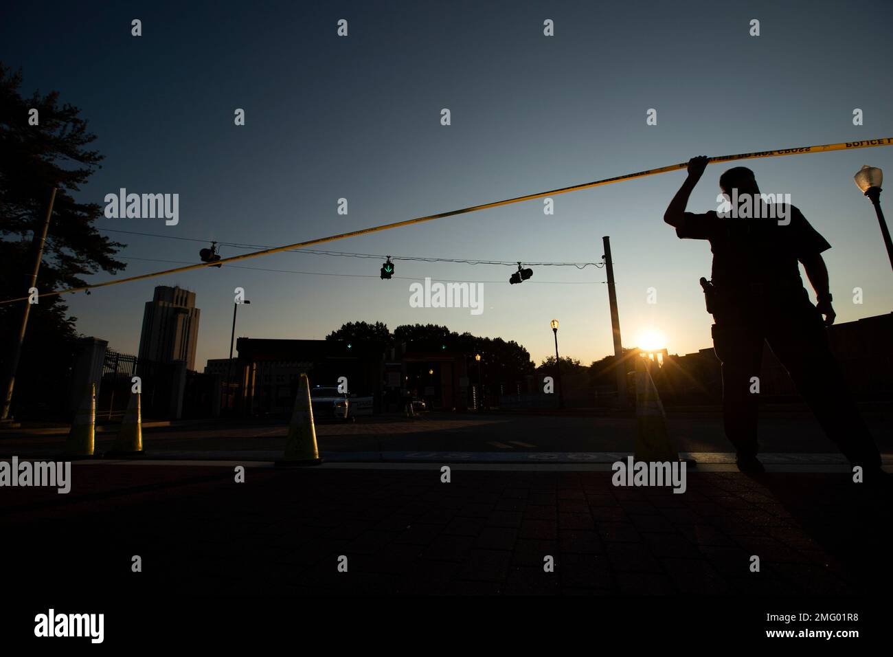 A police officer walks under caution tape at the main gate of Walter ...