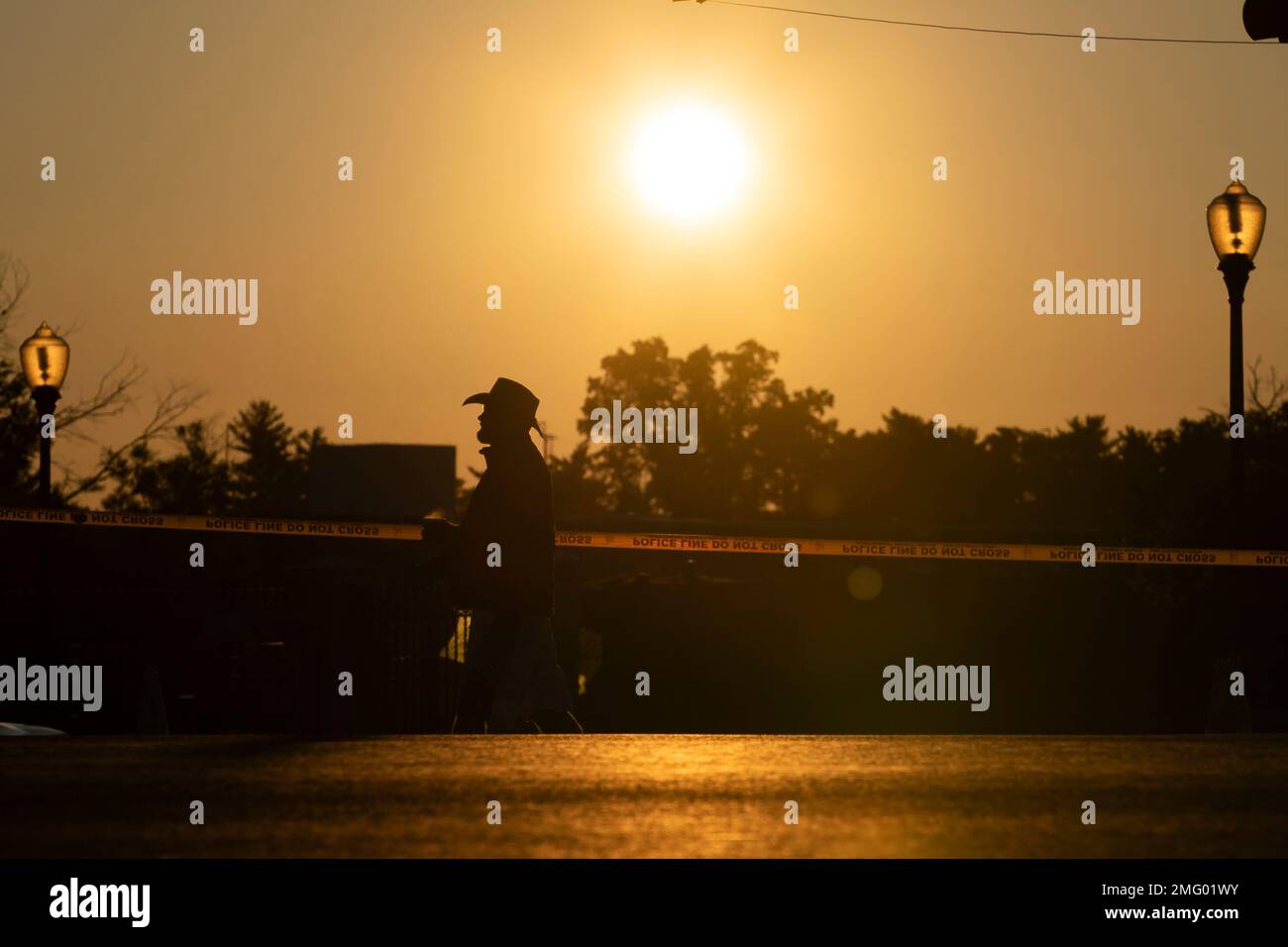 The sun rises as President Donald Trump supporter Richard Potcner walks ...