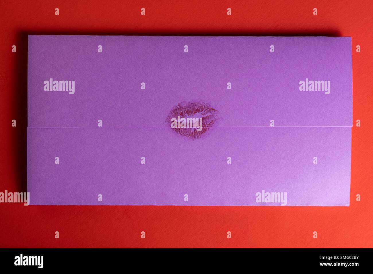 concept for a love note sealed with a kiss photographed on a red ...