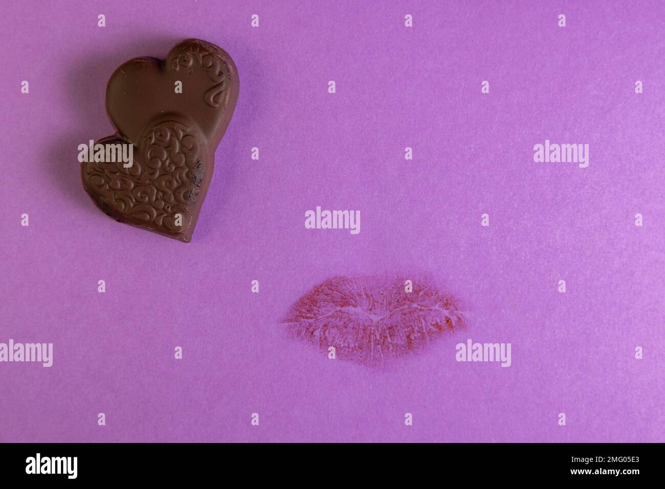 concept for a love note sealed with a kiss and heart shaped chocolates ...