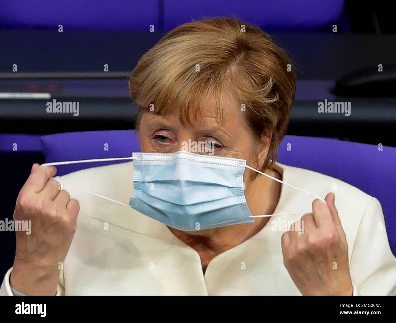 German Chancellor Angela Merkel adjusts her face mask during a budget ...