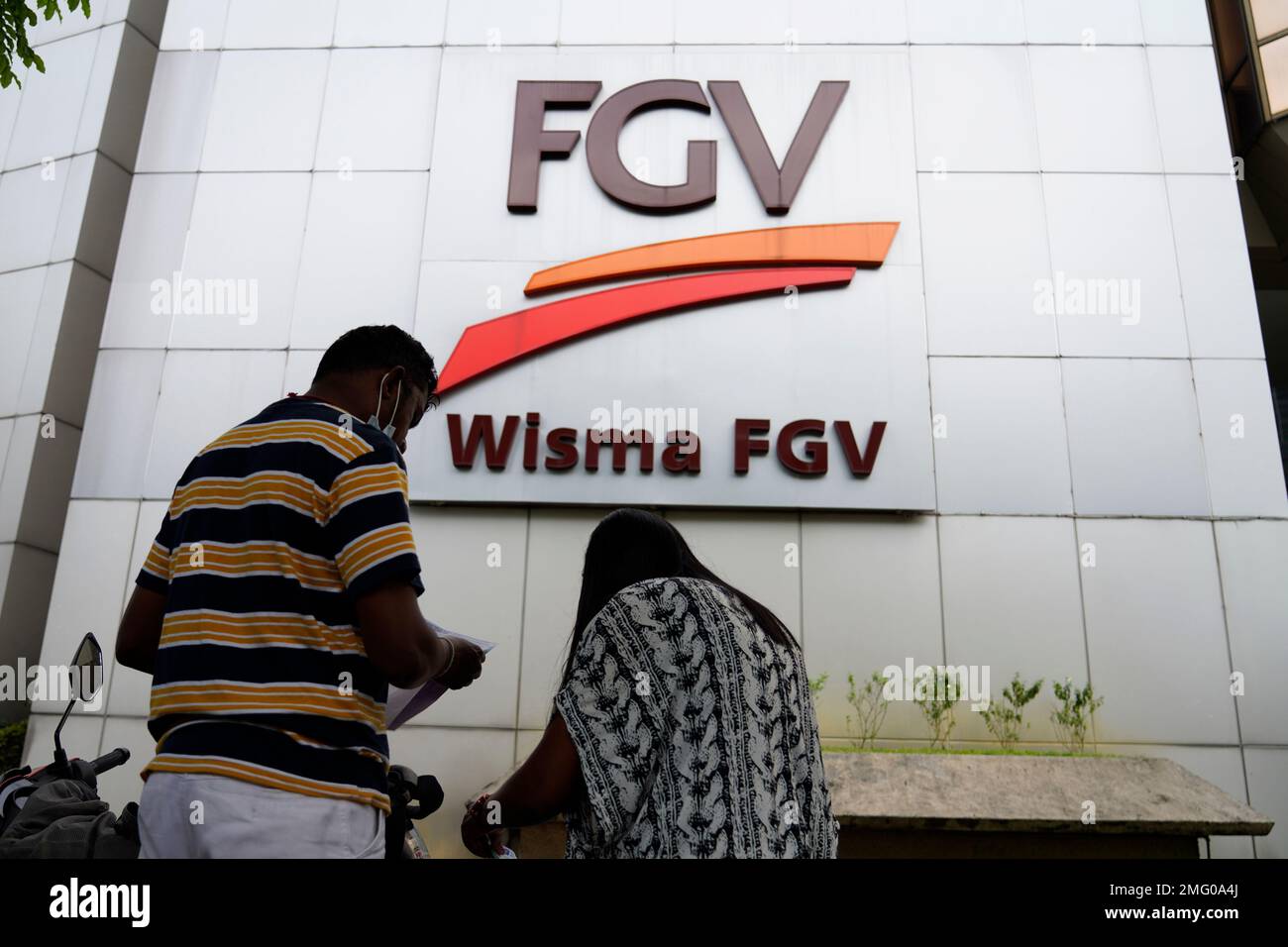 A couple talks outside FGV Holdings Berhad, one of Malaysia's largest ...