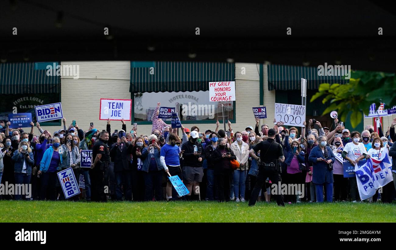People wave a bus with Democratic presidential candidate former Vice ...
