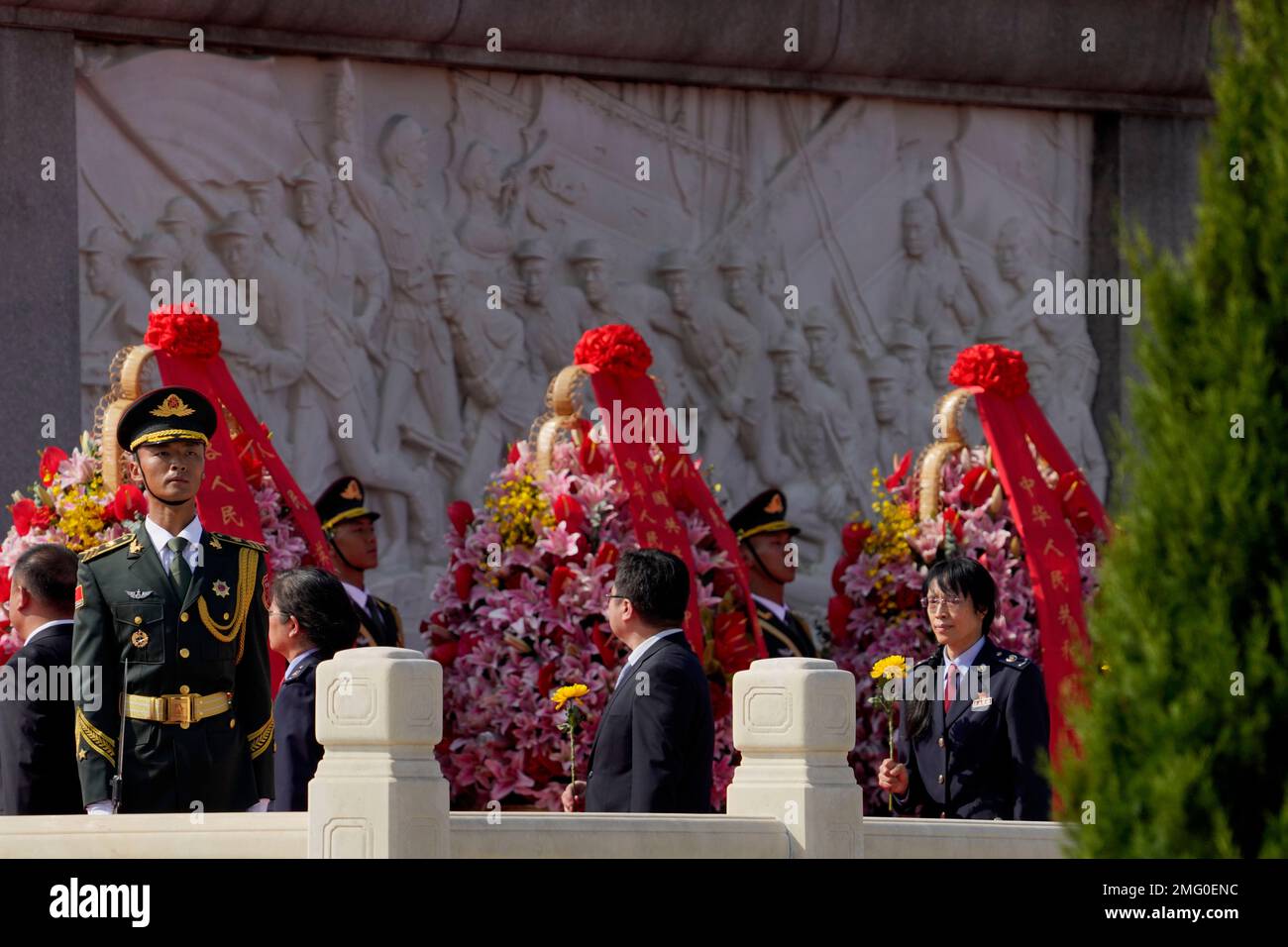 Attendees hold flowers as they pay respect at the Monument to the ...