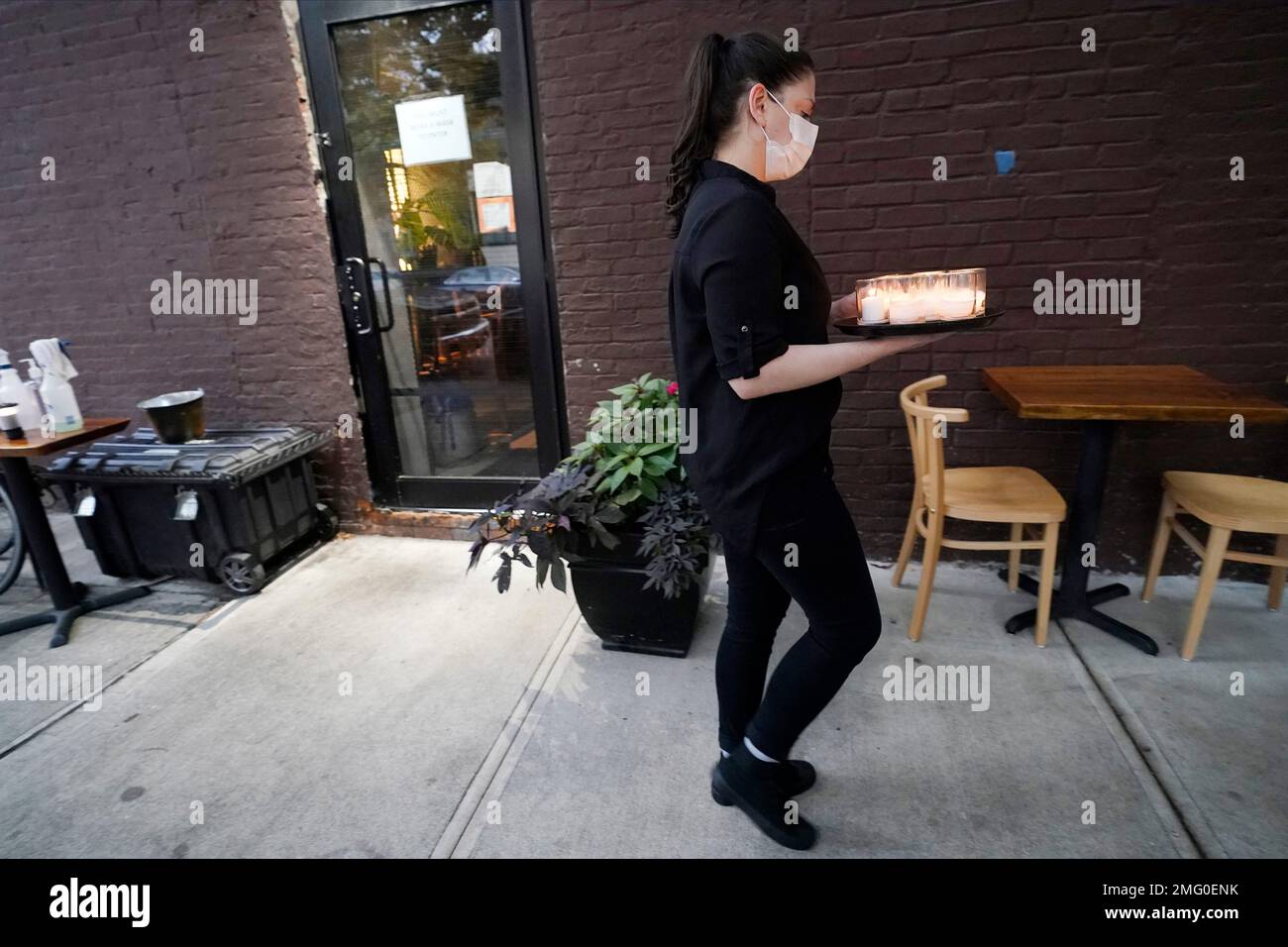 HOLD FOR STORY - Bartender Devon Schickling delivers candles to outdoor ...