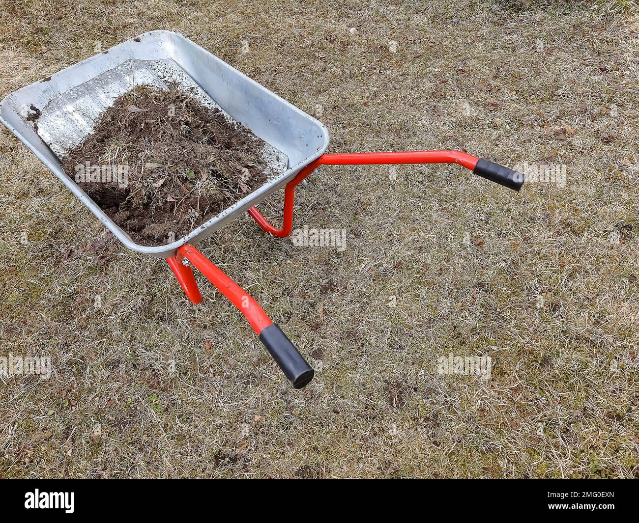 Garden wheelbarrow filled with earth or compost at the farm. Seasonal ...