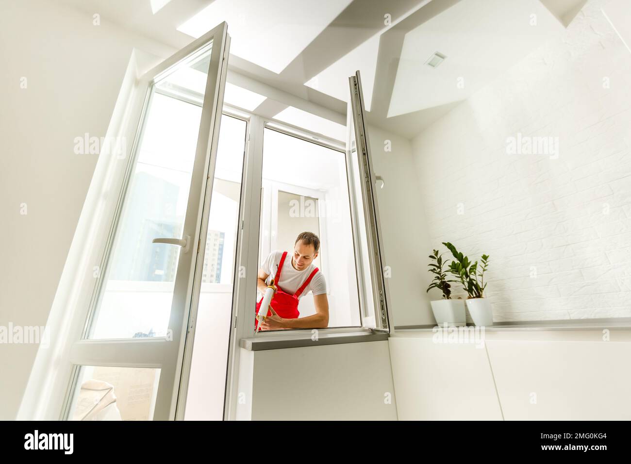 Construction worker installing window in house Stock Photo - Alamy