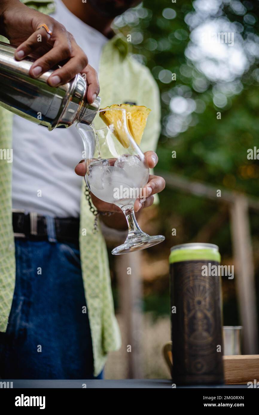 Male bartender pours soda into cocktail while outside Stock Photo - Alamy