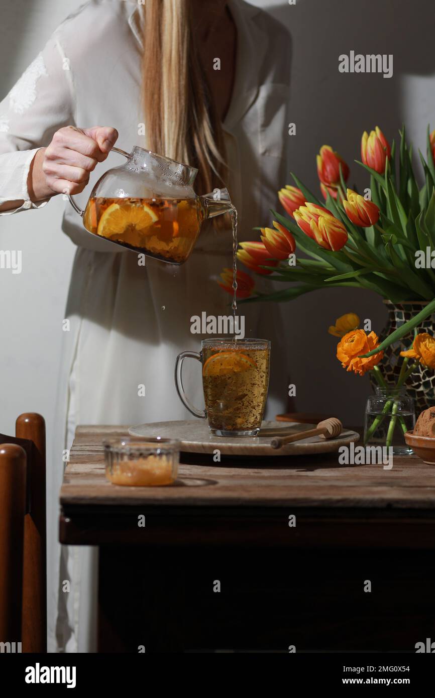 Woman pouring tea from teapot in teaware. Morning tea making time in ...
