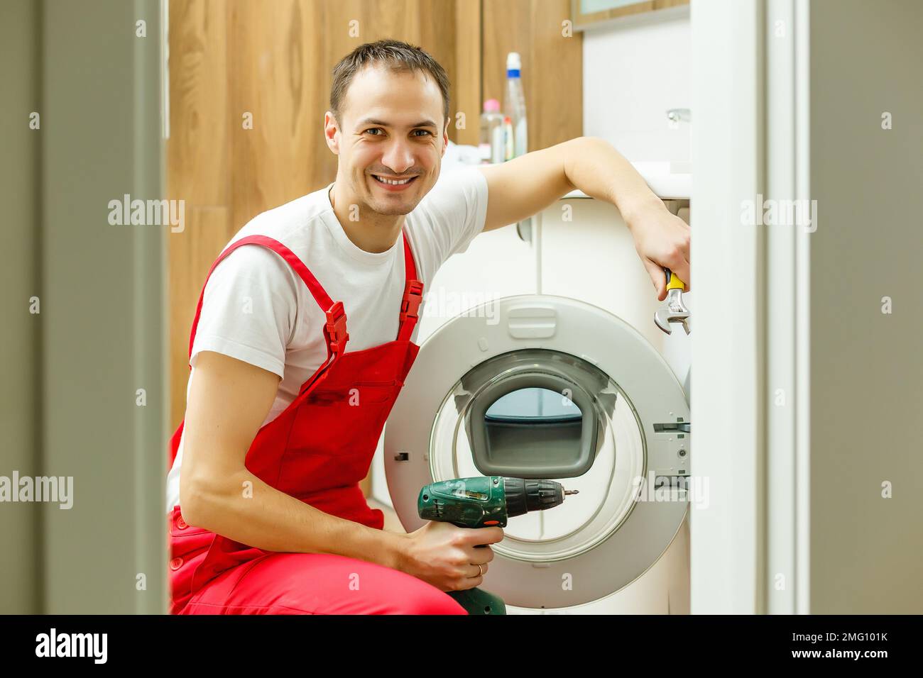 Washing machine repair. Repairer hands with screwdriver disassembling ...
