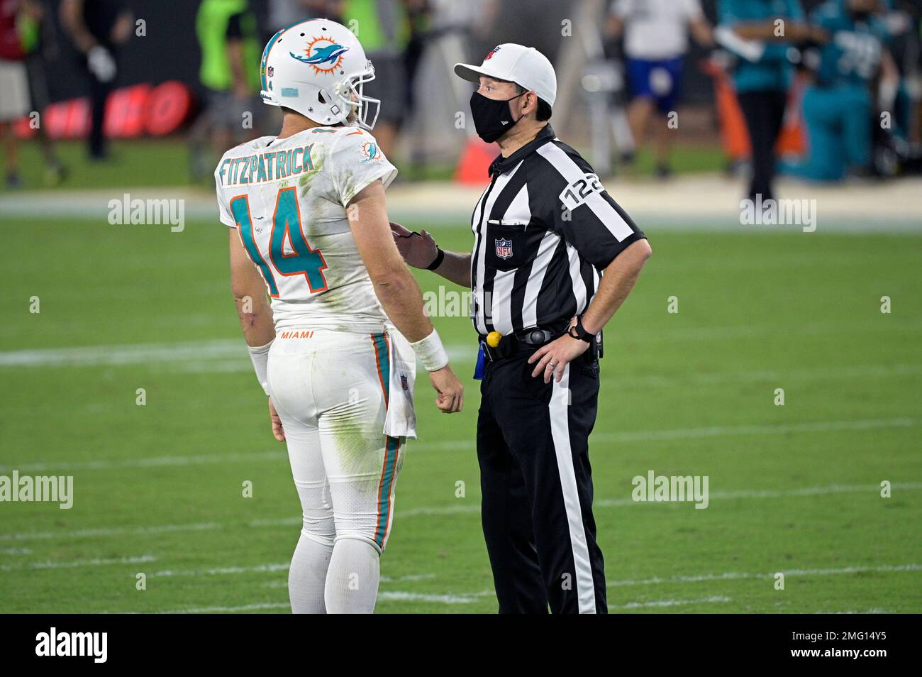 Referee Brad Allen (122) talks to Miami Dolphins quarterback Ryan ...