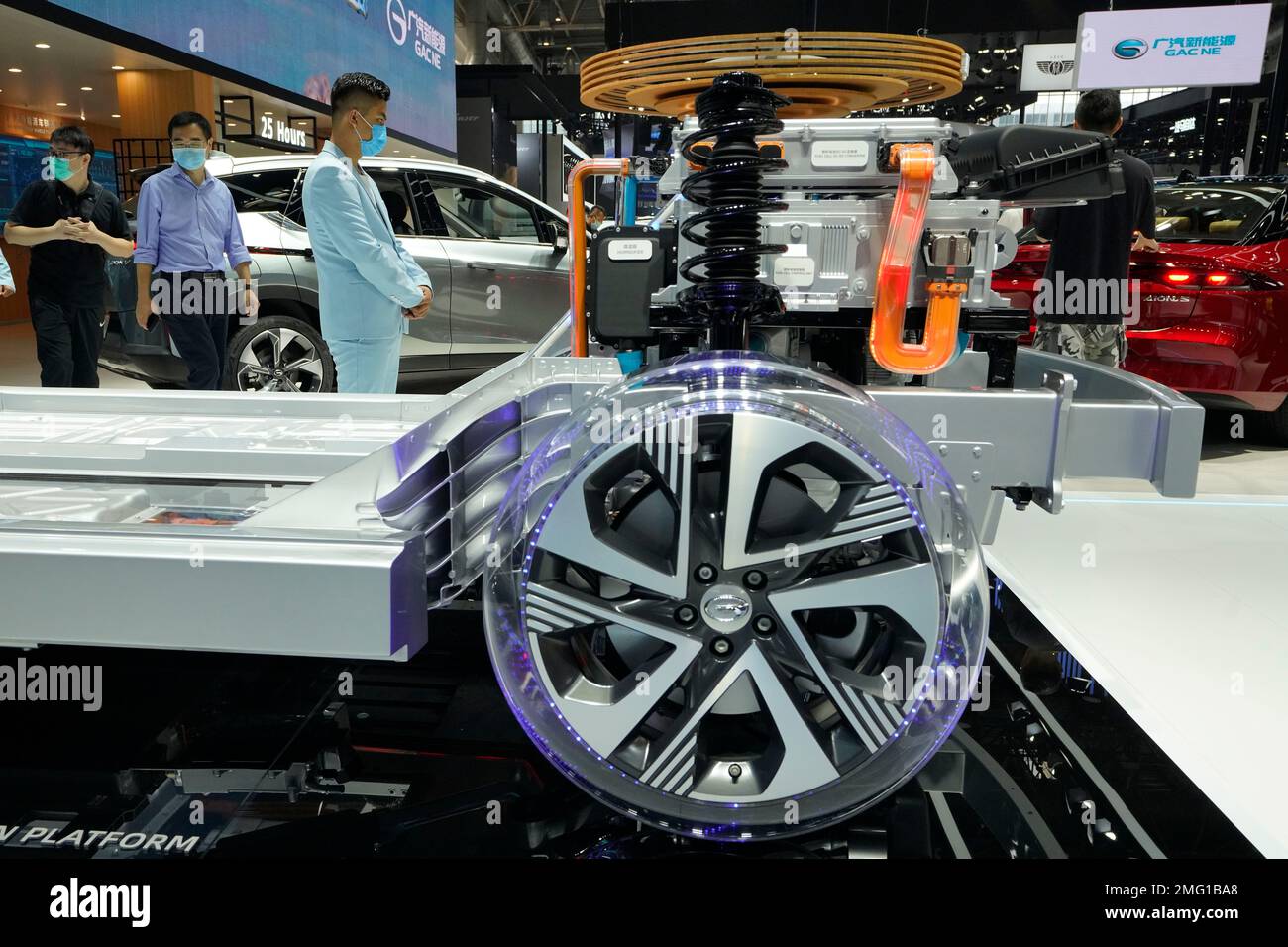 Attendees wearing masks to protect from the coronavirus past by a model ...