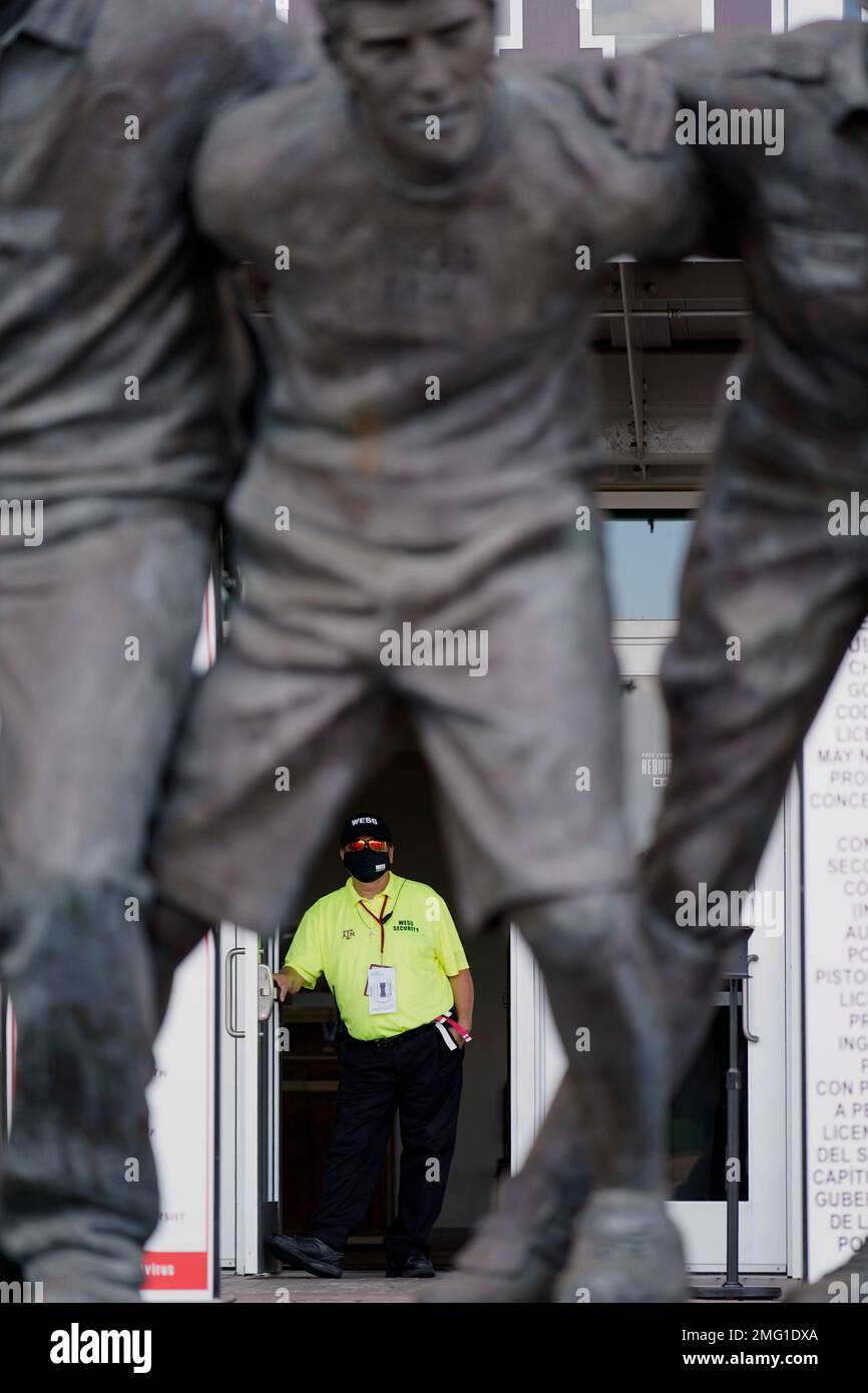 A security guard wears a mask while stationed at an entrance to Kyle ...
