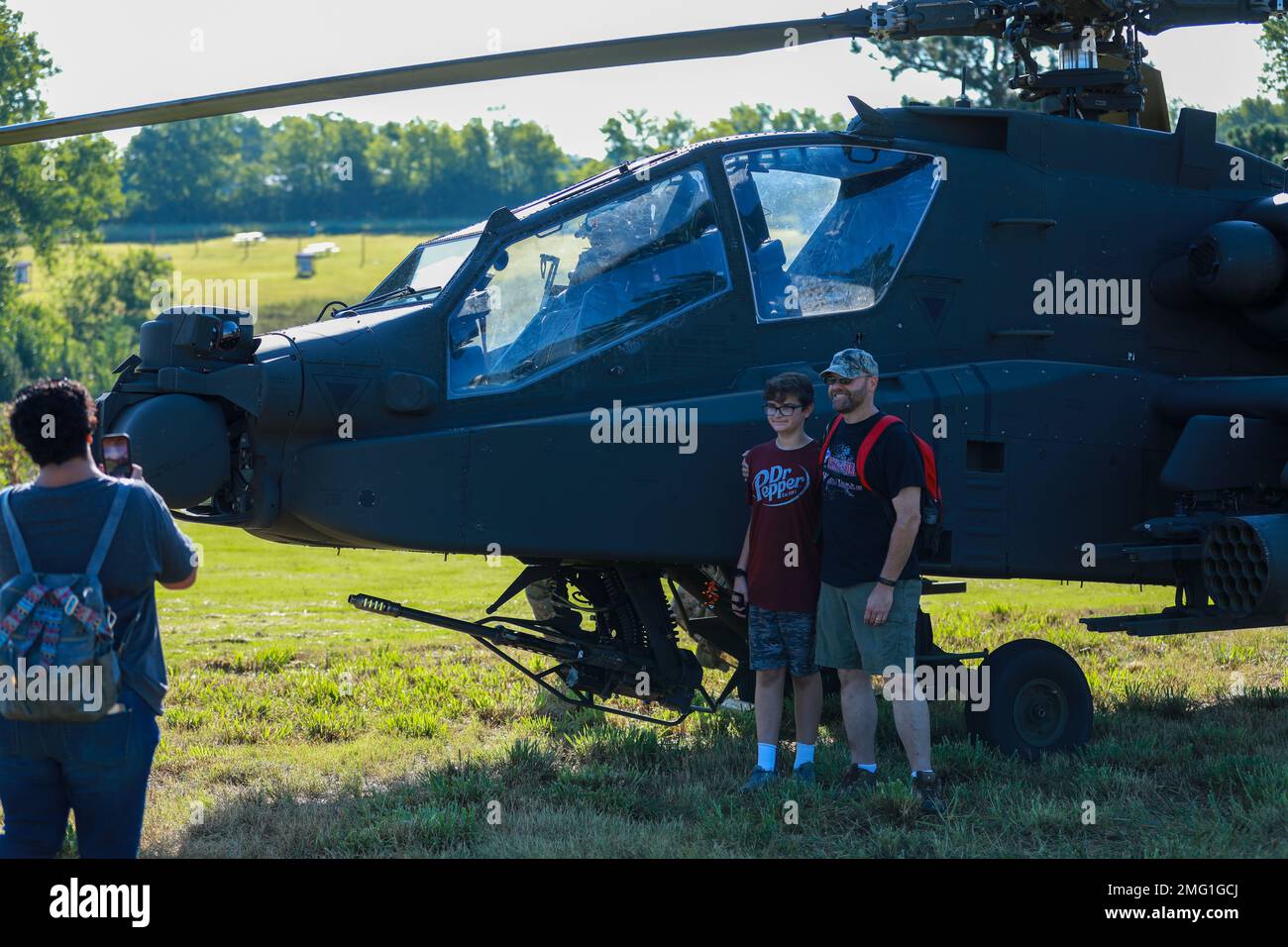 Fort Riley community members pose beside a Boeing AH-64 Apache ...