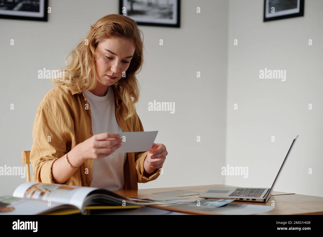 Concentrated art gallery manager choosing photos for new exhibition ...