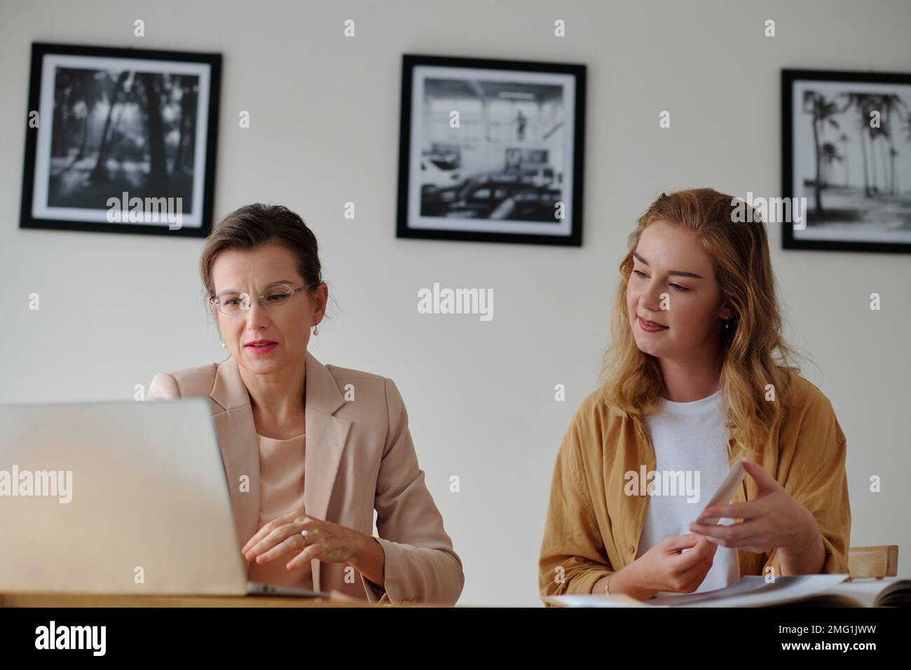 Art gallery managers selecting photos and pictures for new exhibition ...