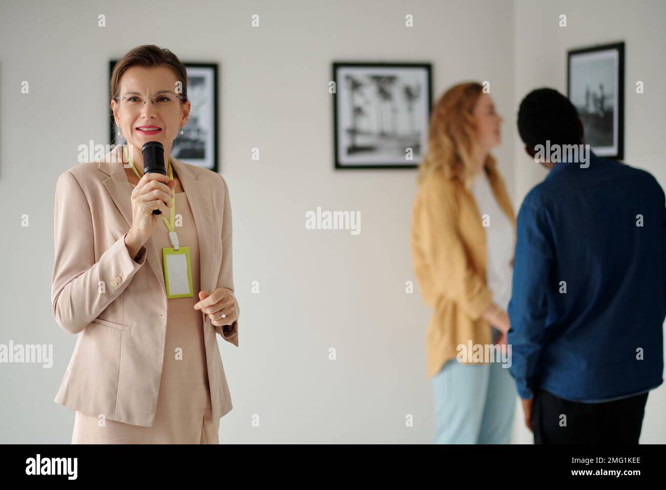 Positive museum guide talking about new exhibition of black and white ...