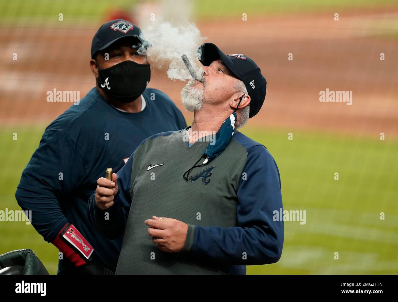 The Atlanta Braves pitching coach Rick Kranitz lights a cigar in ...
