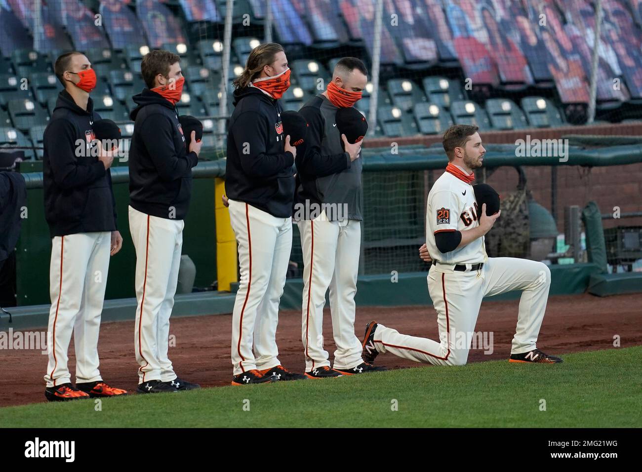 San Francisco Giants' Austin Slater, right, kneels during the national ...