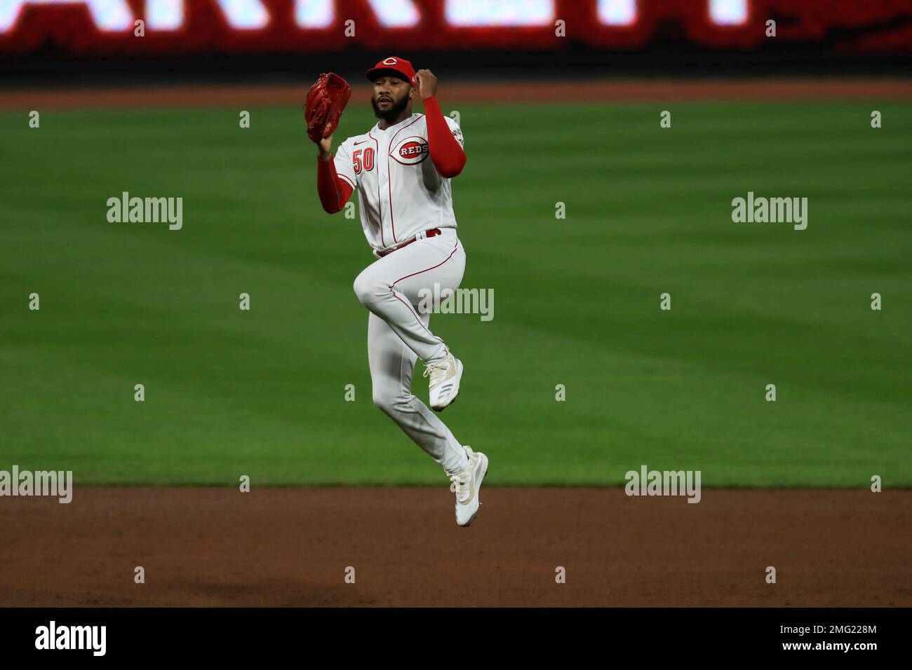 Cincinnati Reds' Amir Garrett leaps as he takes the field during a ...