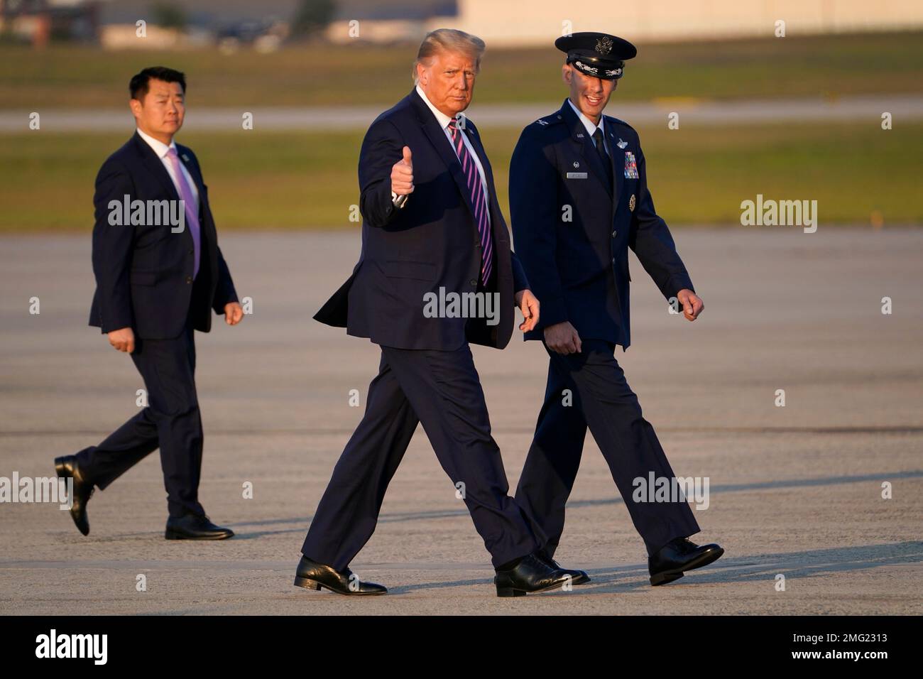 President Donald Trump, center, walks towards Air Force One with Col ...
