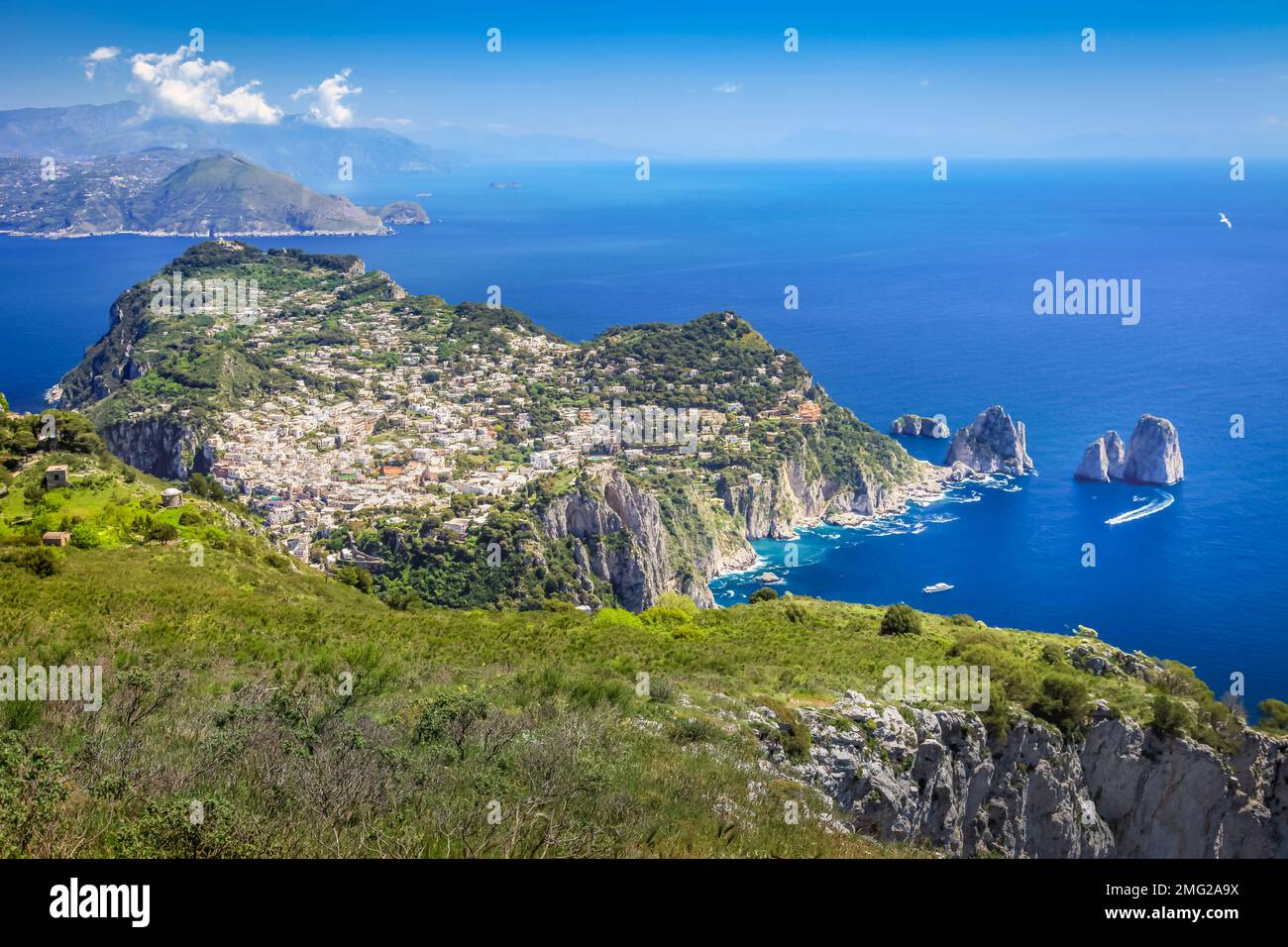 Above Capri city cliffs and Faraglioni with boats and yacht, amalfi ...