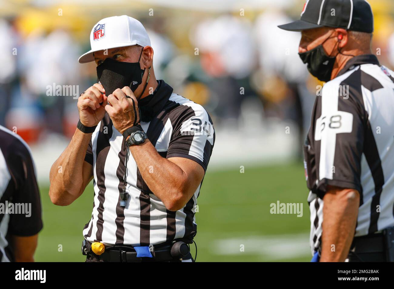 Referee Clete Blakeman puts on a mask during an NFL football game ...